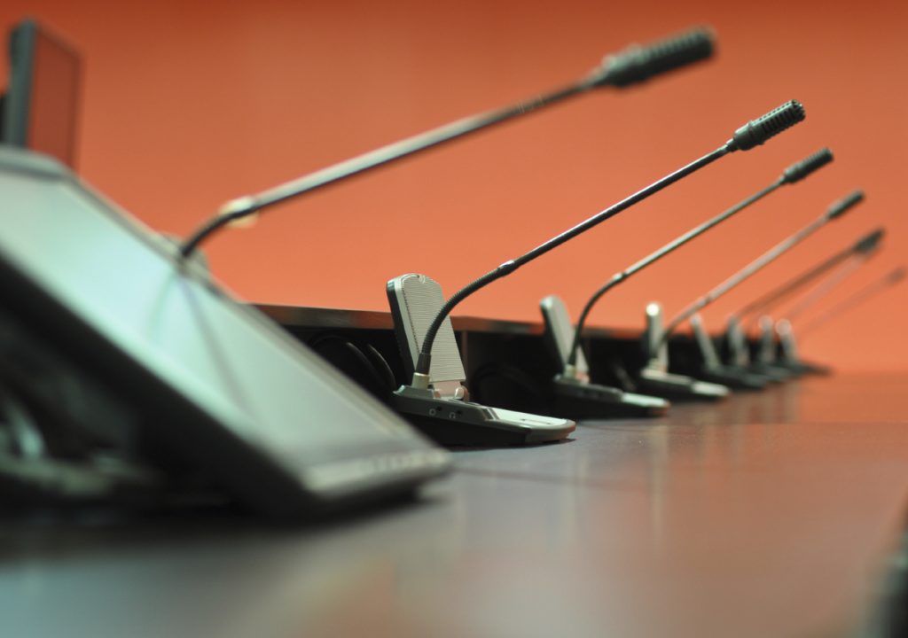 Conference table, microphones and office chairs close-up